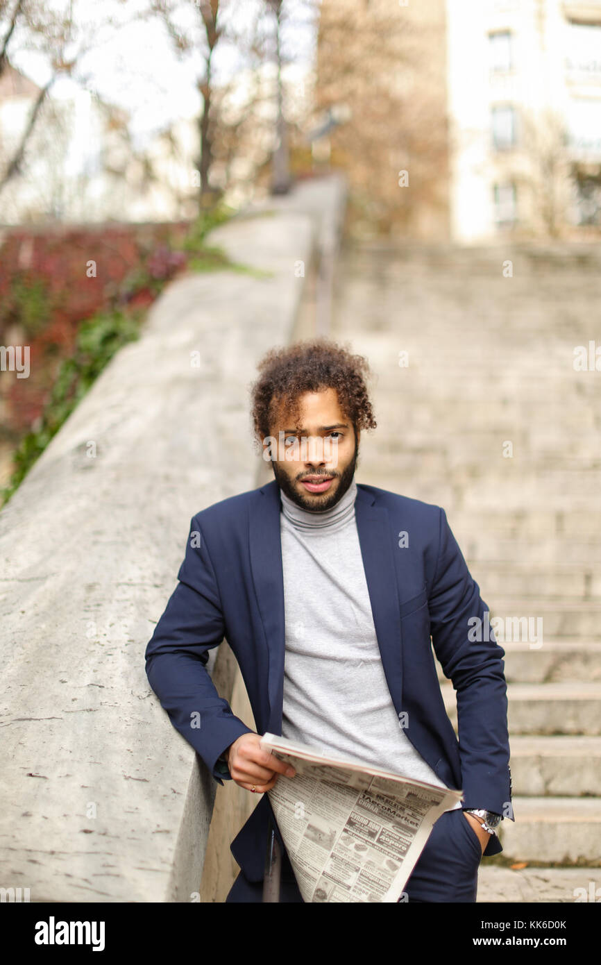Young male model reading newspaper on open air Stock Photo - Alamy