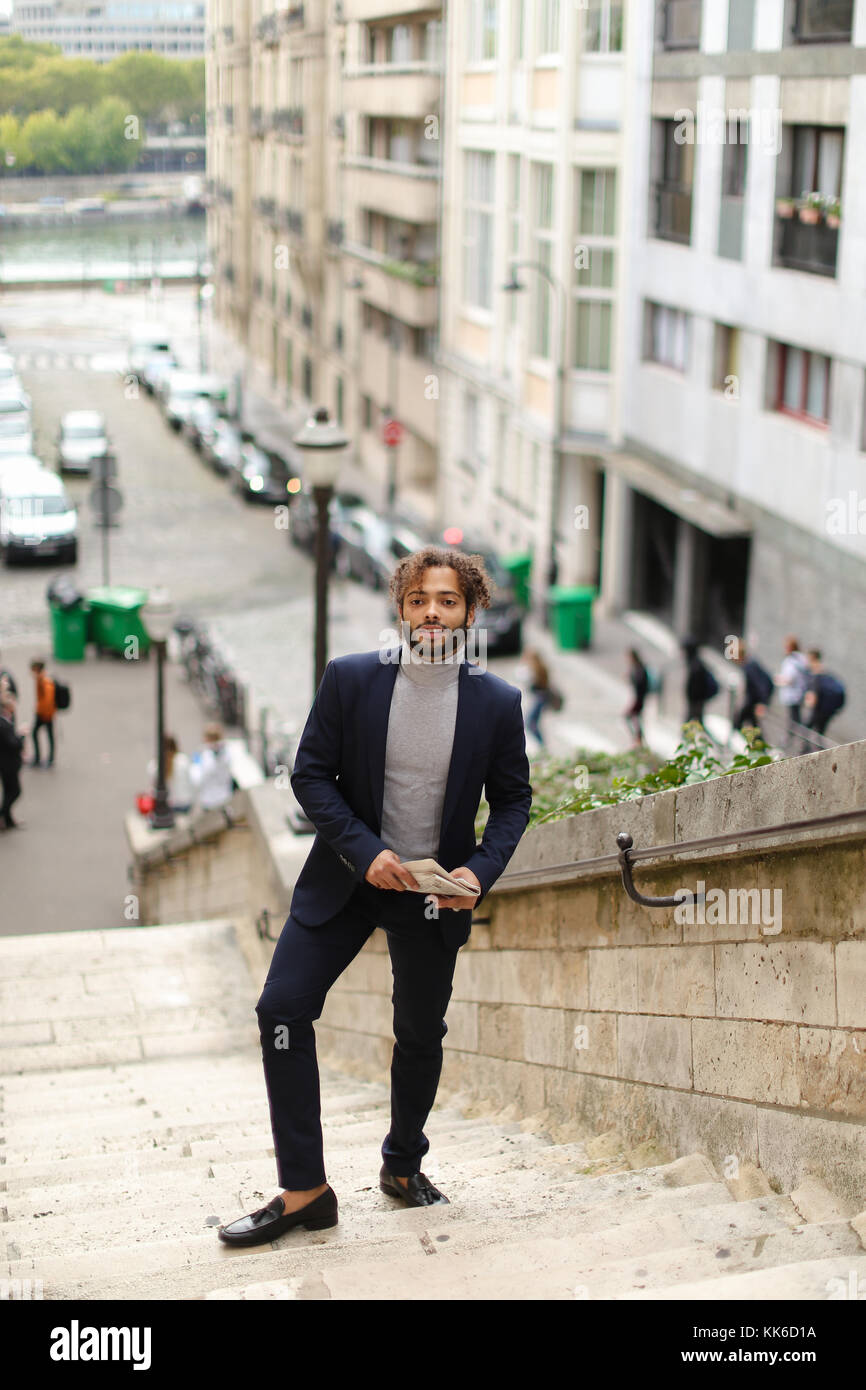 Handsome mix blood man walking down steps with newspaper Stock Photo ...