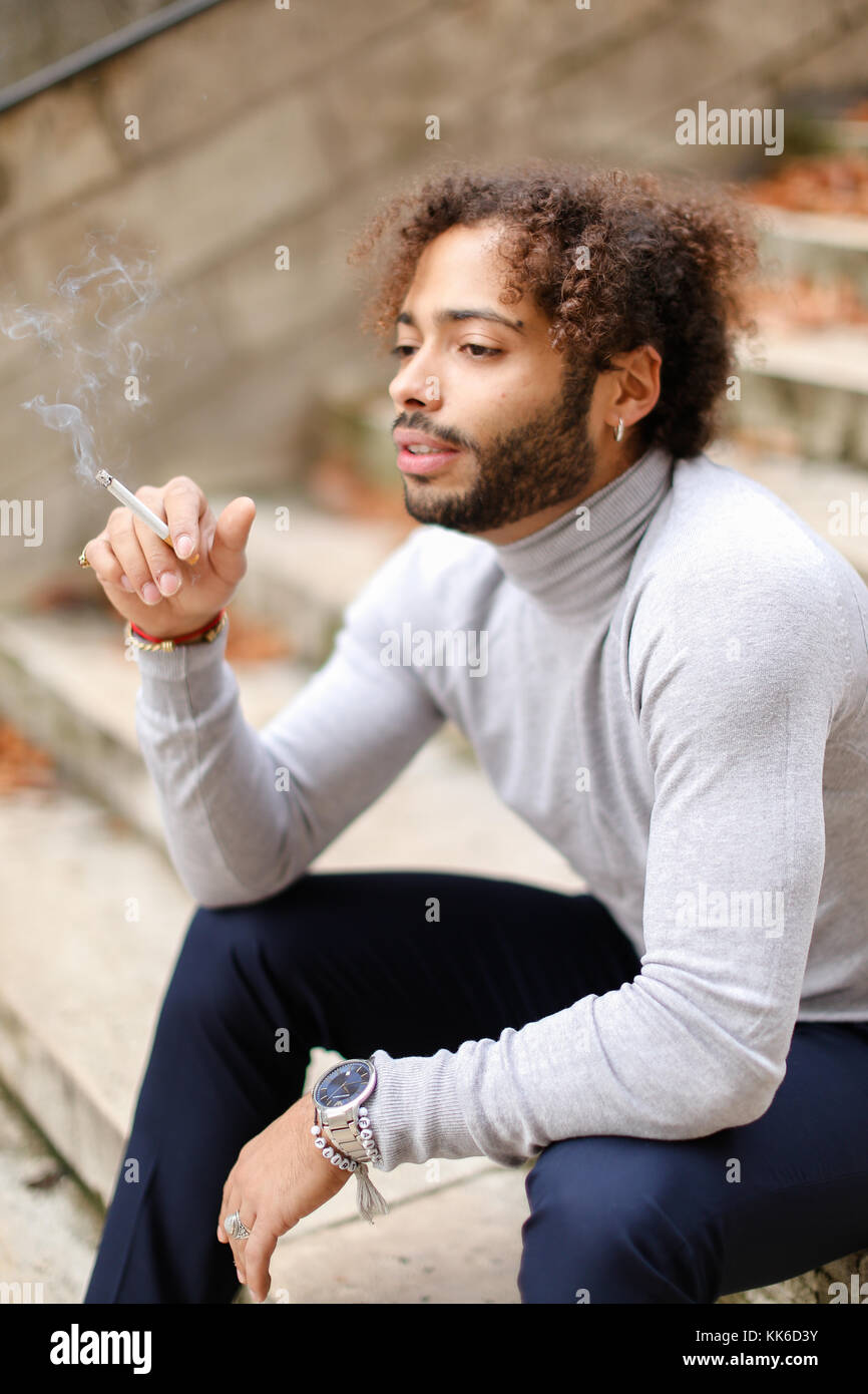 Sad mix blood man smoking on steps Stock Photo - Alamy