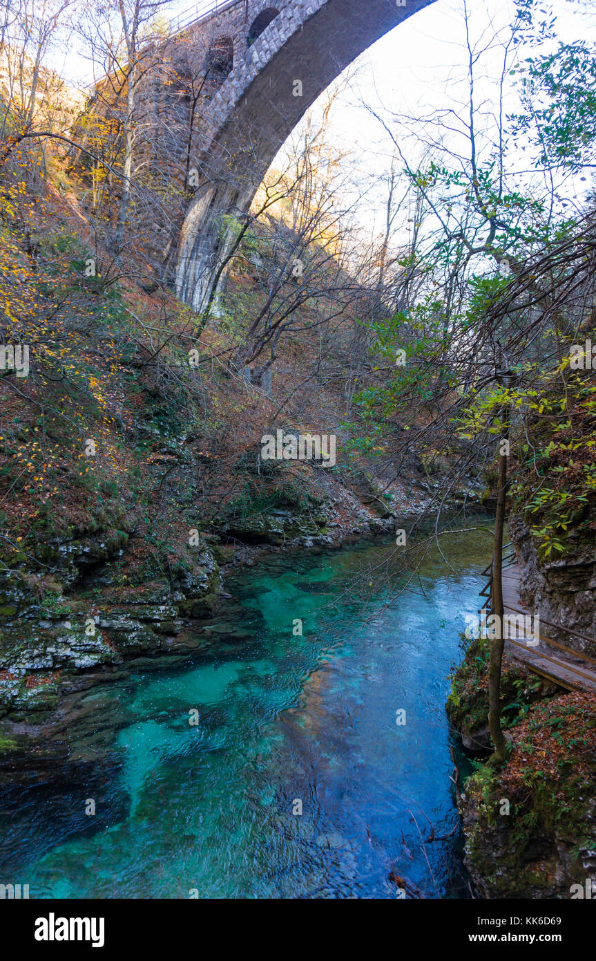 The pristine Radovna river and a tall, stone bridge spanning the ...