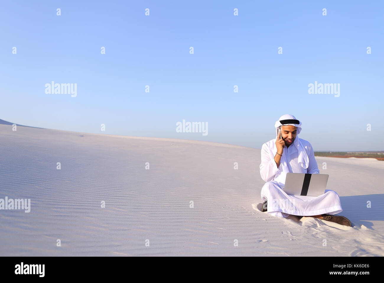 Successful Muslim male architect communicates on phone with clie Stock ...