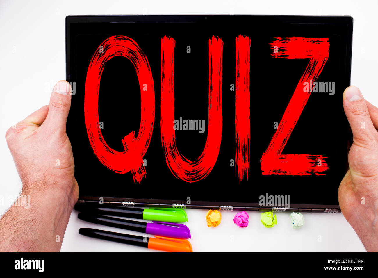 Quiz text written on tablet, computer in the office with marker, pen ...