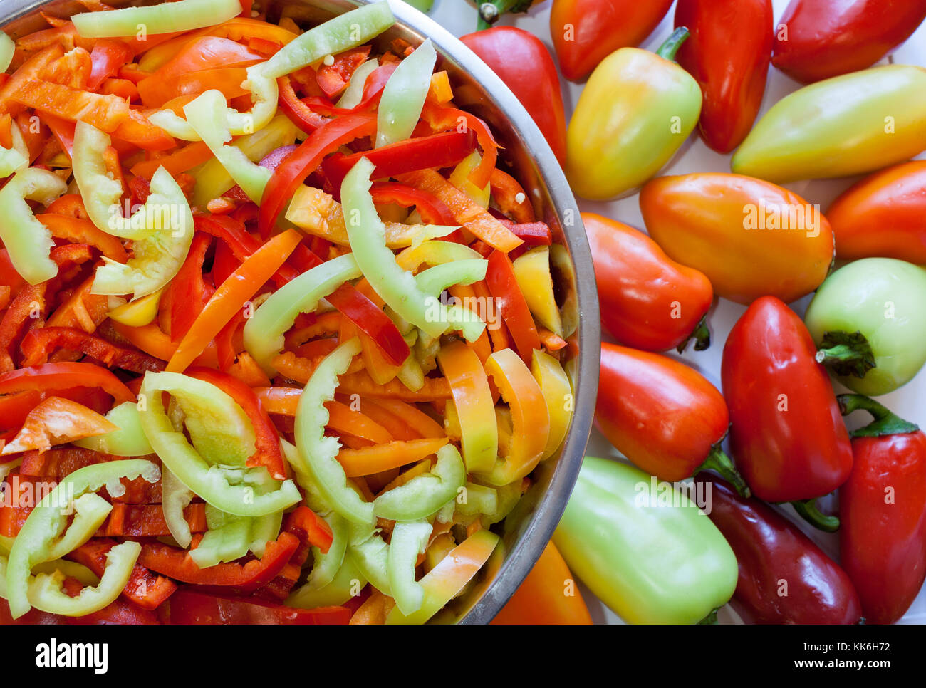 Sliced lengthwise stripes of multi-colored peppers are lying in round ...