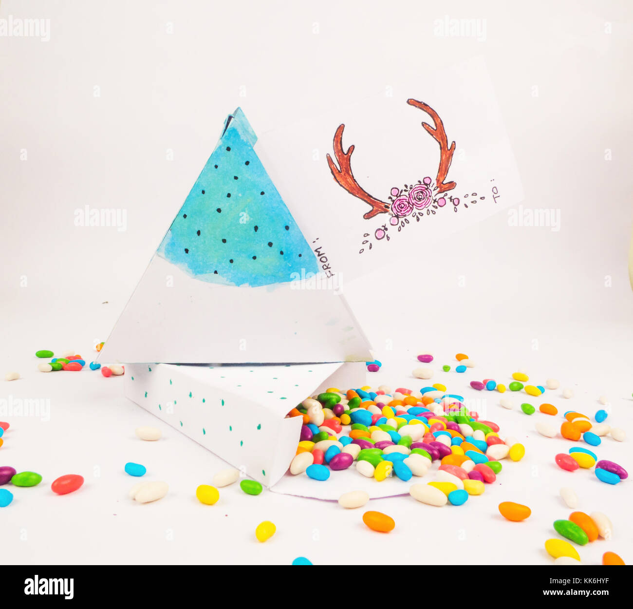 Christmas decoration triangle gift boxes with colorful candies close up ...