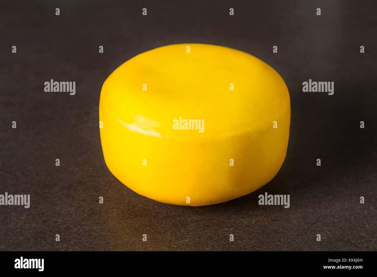 Round gouda cheese. Dark background Stock Photo - Alamy