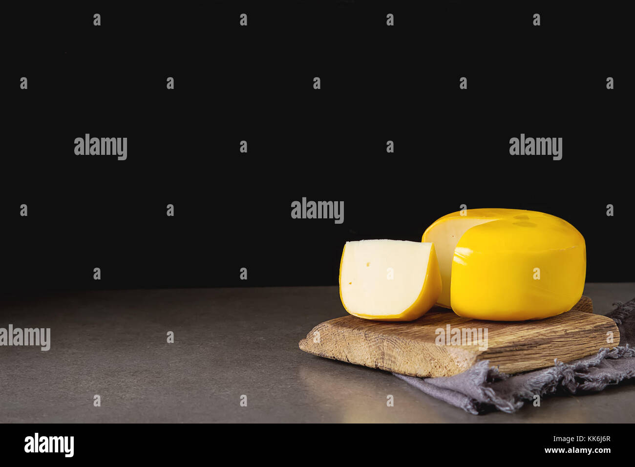 Round gouda cheese. Dark background Stock Photo - Alamy