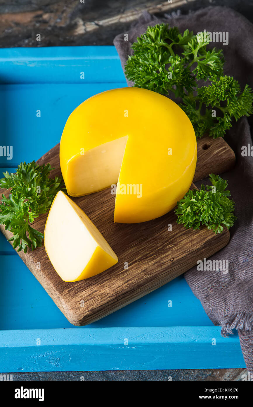Round gouda cheese with parsley. Dark background Stock Photo - Alamy