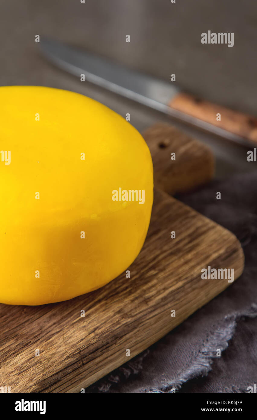 Round gouda cheese. Dark background Stock Photo - Alamy