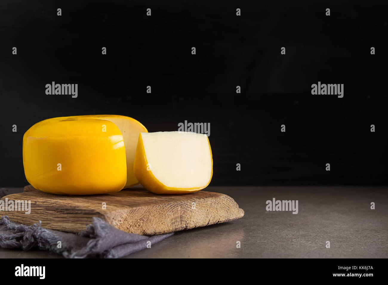 Round gouda cheese. Dark background Stock Photo - Alamy
