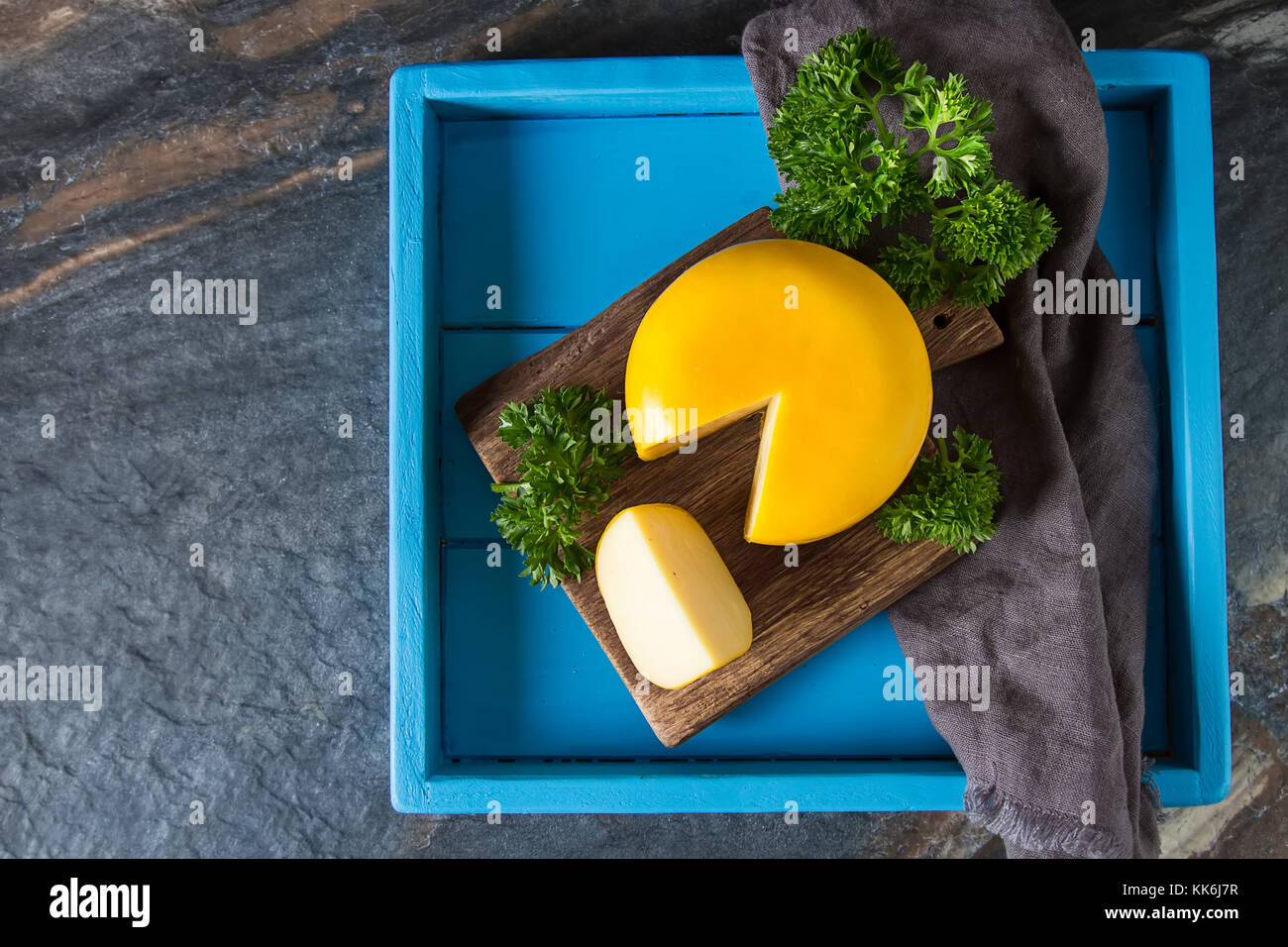 Round gouda cheese with parsley. Dark background Stock Photo - Alamy