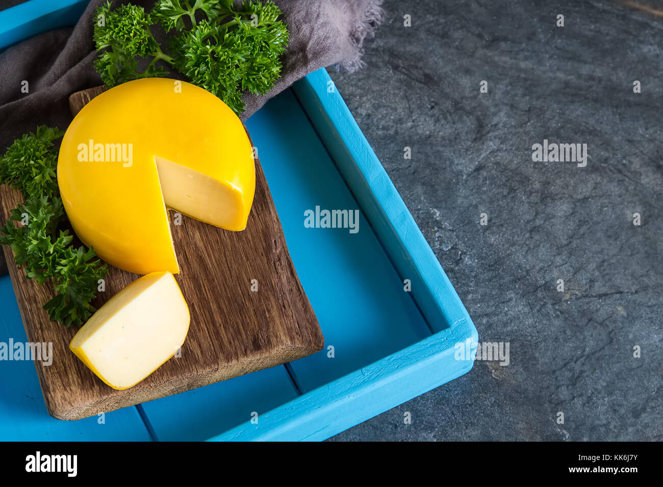 Round gouda cheese with parsley. Dark background Stock Photo - Alamy