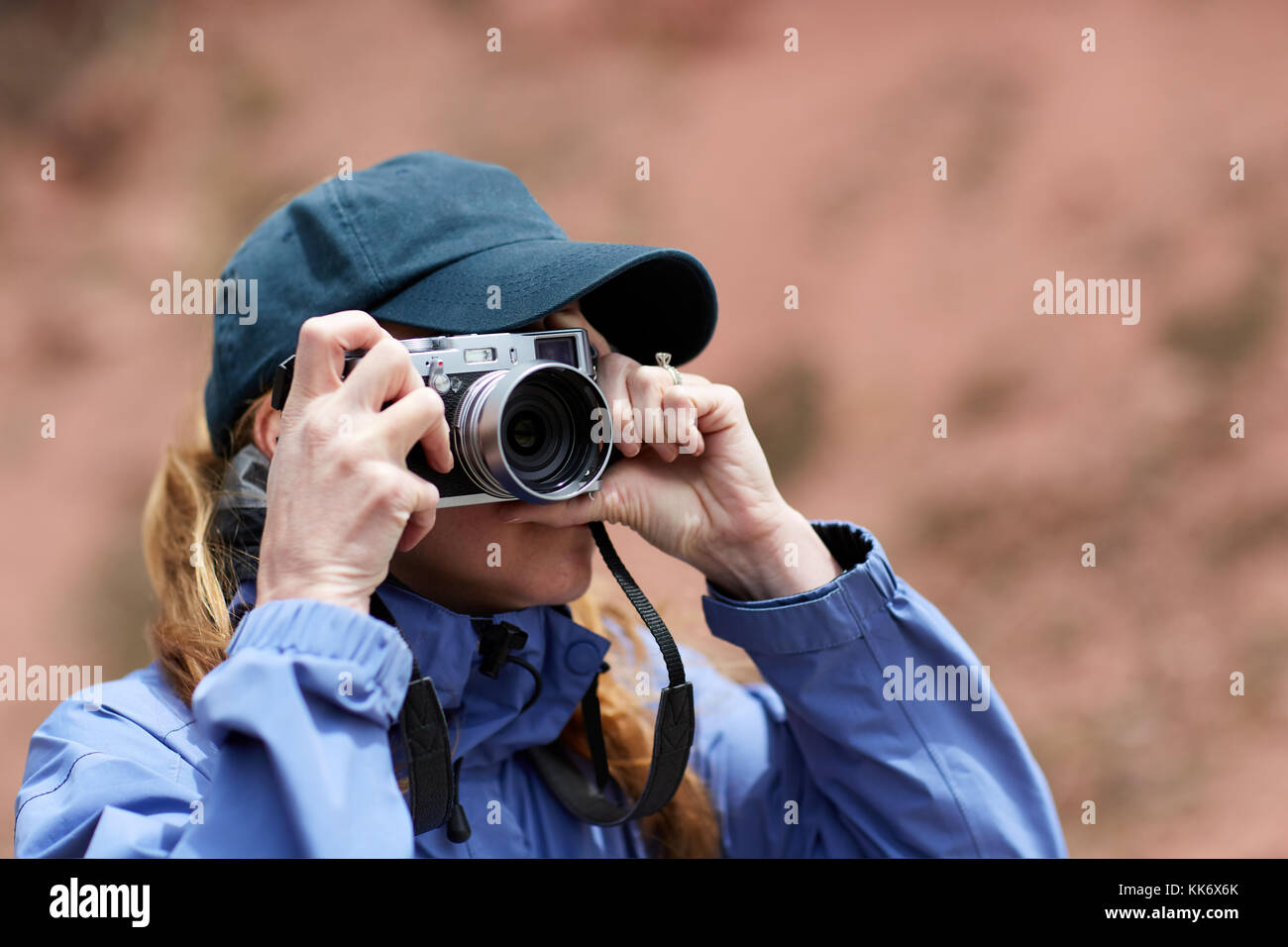 Inspired young woman wearing a blue cap while photographing nature ...