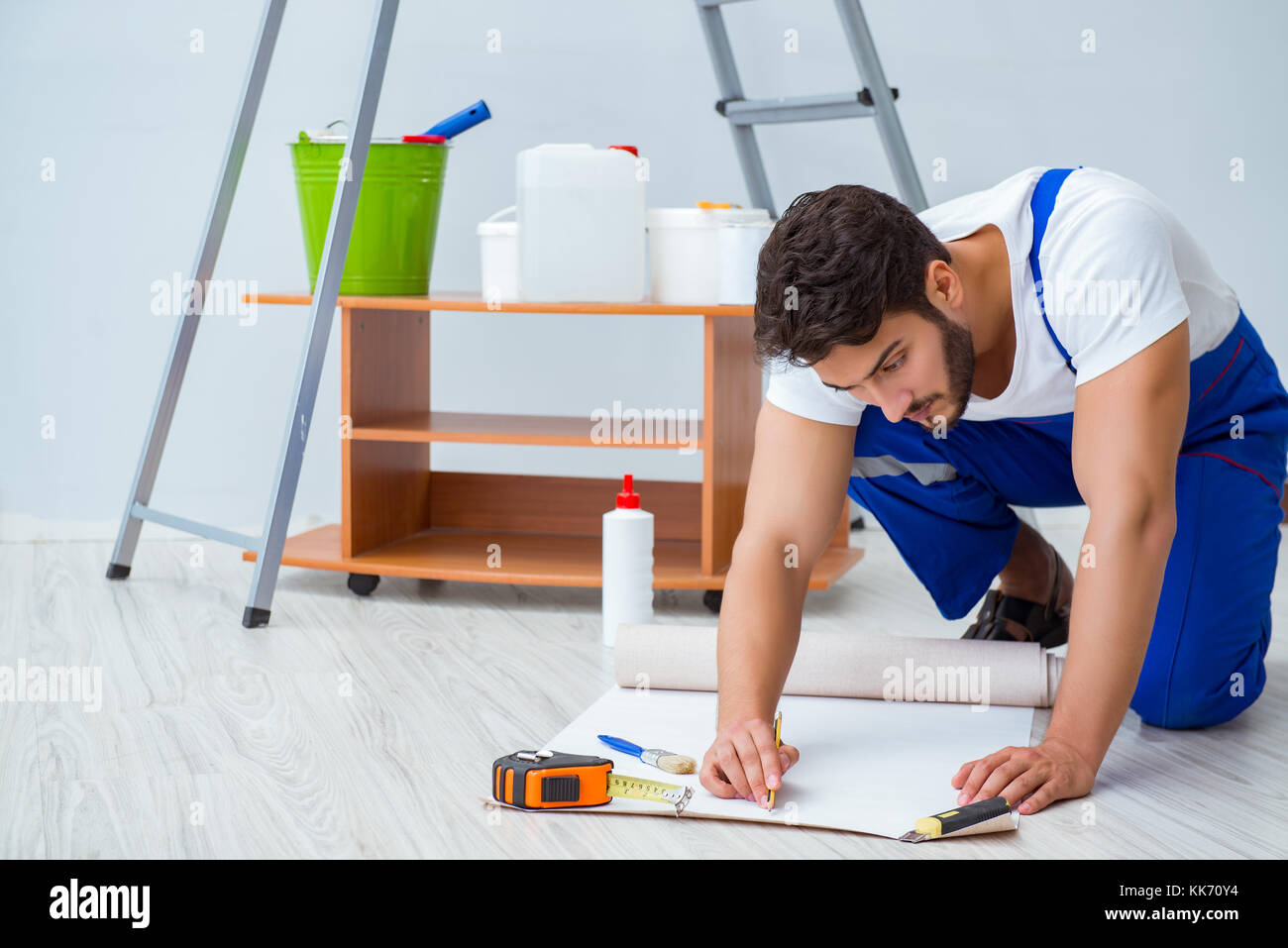 Repairman doing renovation repair in the house with paper wallpaper ...