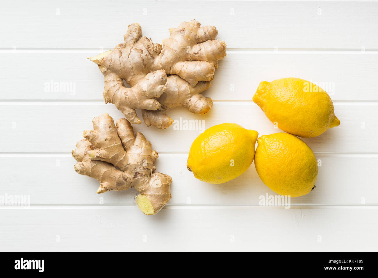 Ginger root and lemons on white table Stock Photo - Alamy