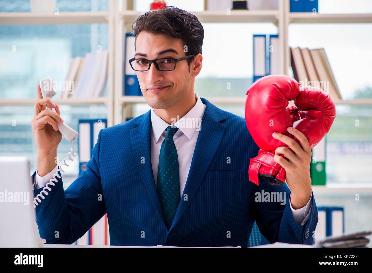 Businessman with boxing gloves angry in office Stock Photo - Alamy