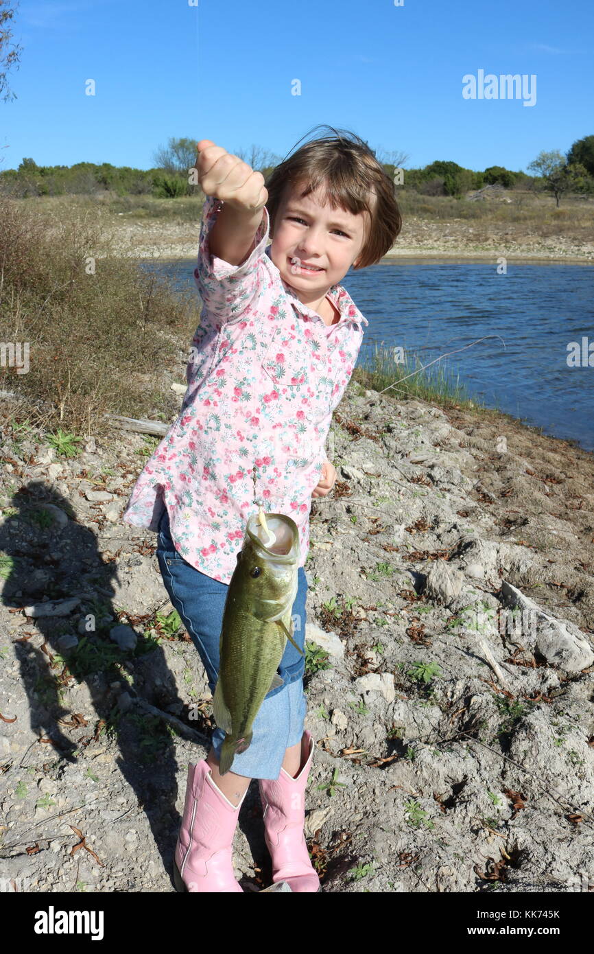 Little girl proudly showing bass she caught fishing Stock Photo - Alamy