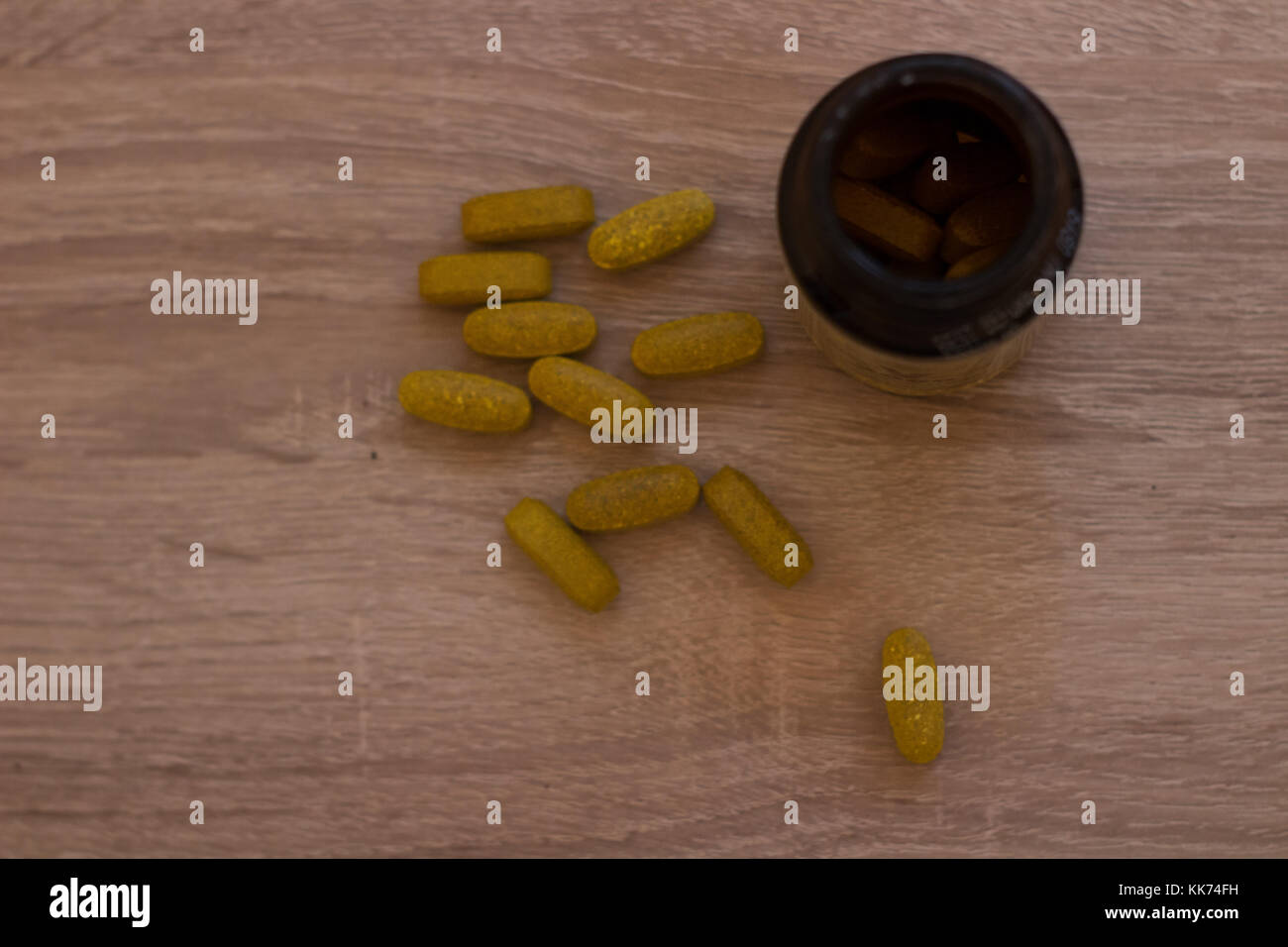 vitamins on a wood table tablets and pills and empty bottle Stock Photo ...