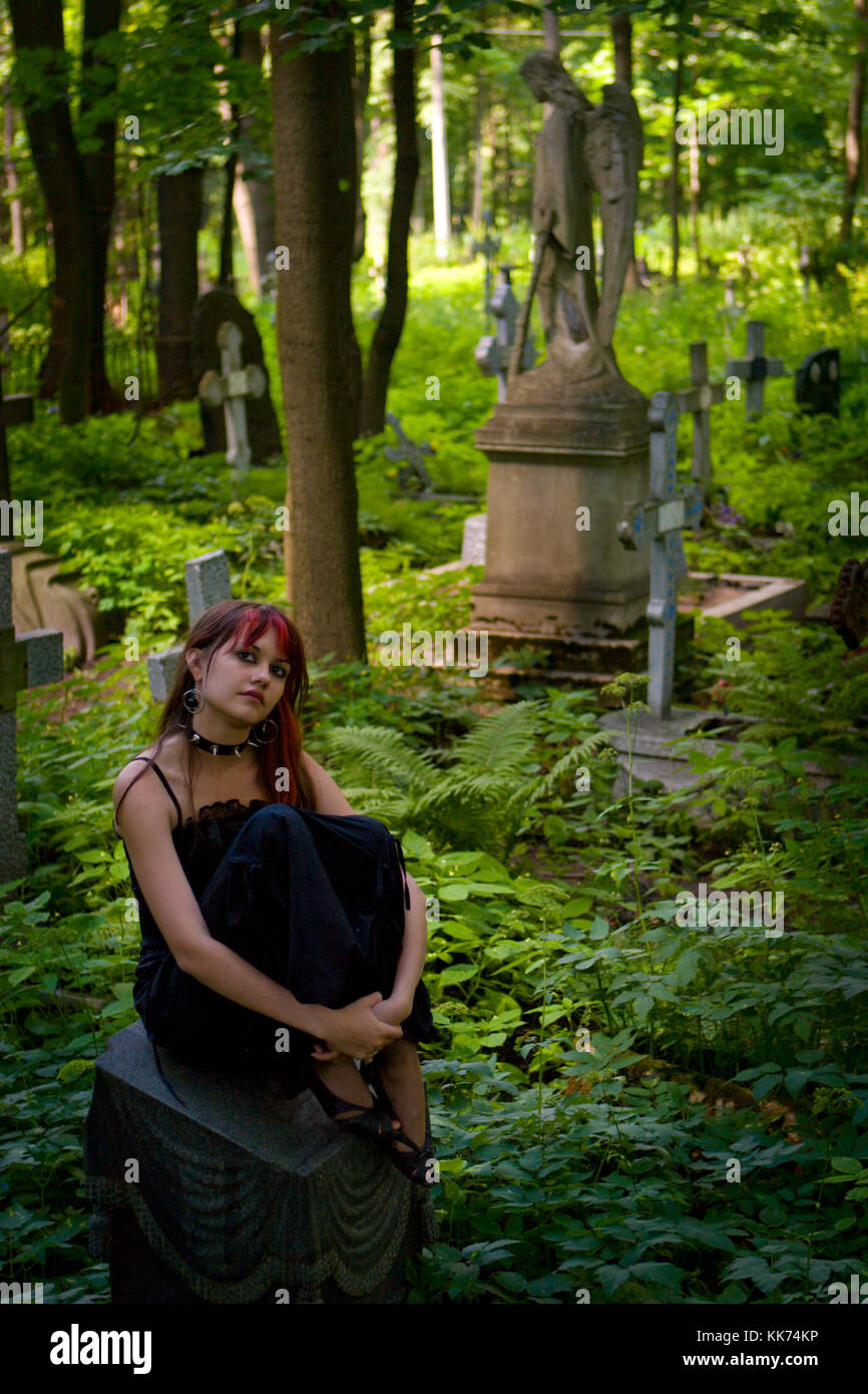 Gothic girl walking through cemetery looking away Stock Photo - Alamy