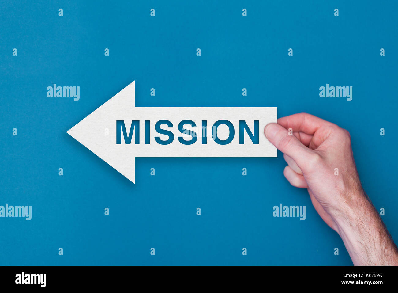 Mission arrow direction held on a blue background Stock Photo - Alamy