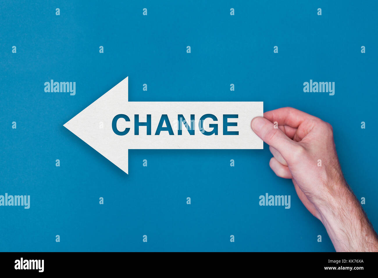 Change arrow direction held on a blue background Stock Photo - Alamy