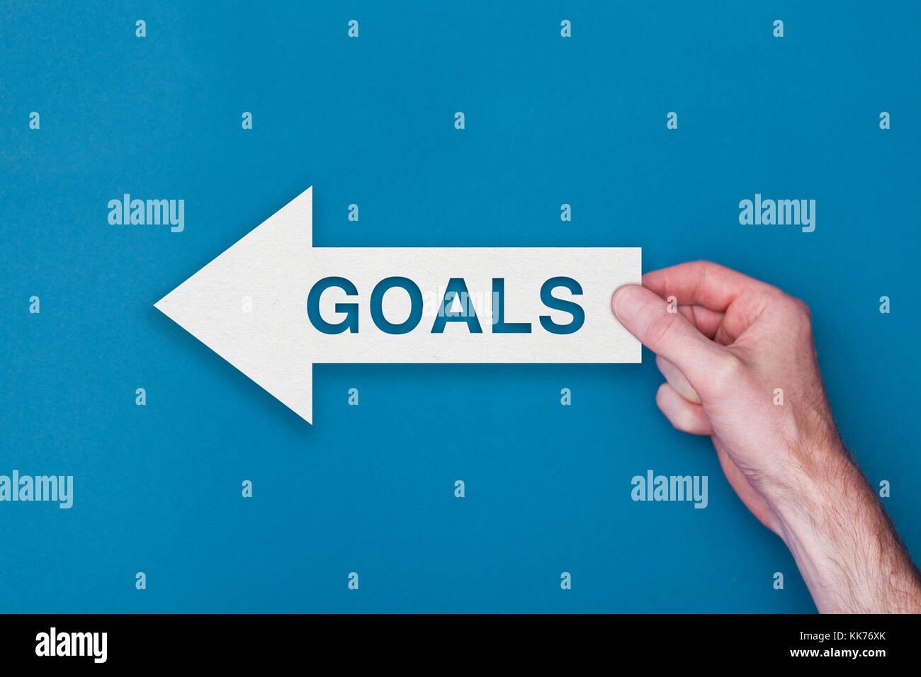 Goals arrow direction held on a blue background Stock Photo - Alamy
