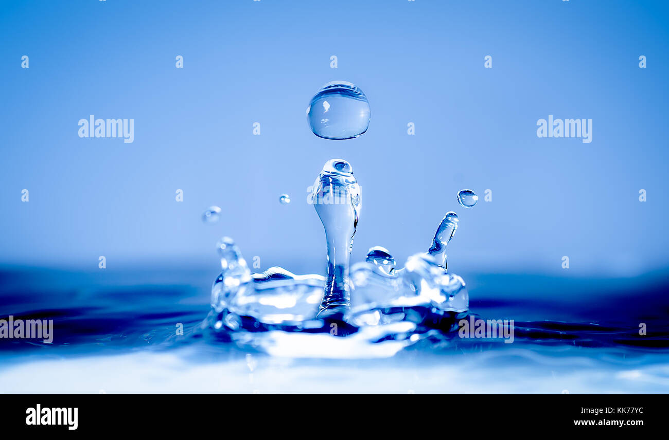 Close up of water drops dropping into water Stock Photo - Alamy