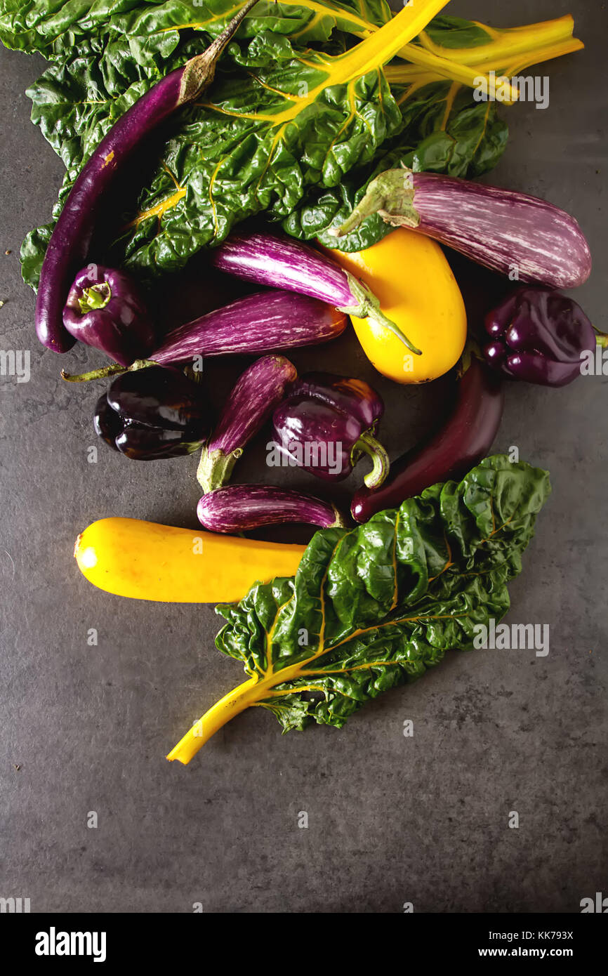 Small eggplant, yellow zucchini, chard and purple pepper. Dark ...