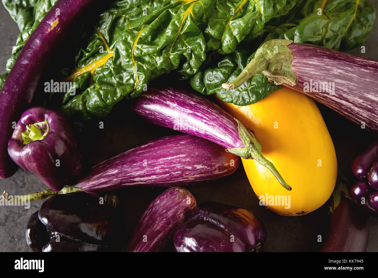 Small eggplant, yellow zucchini, chard and purple pepper. Dark ...