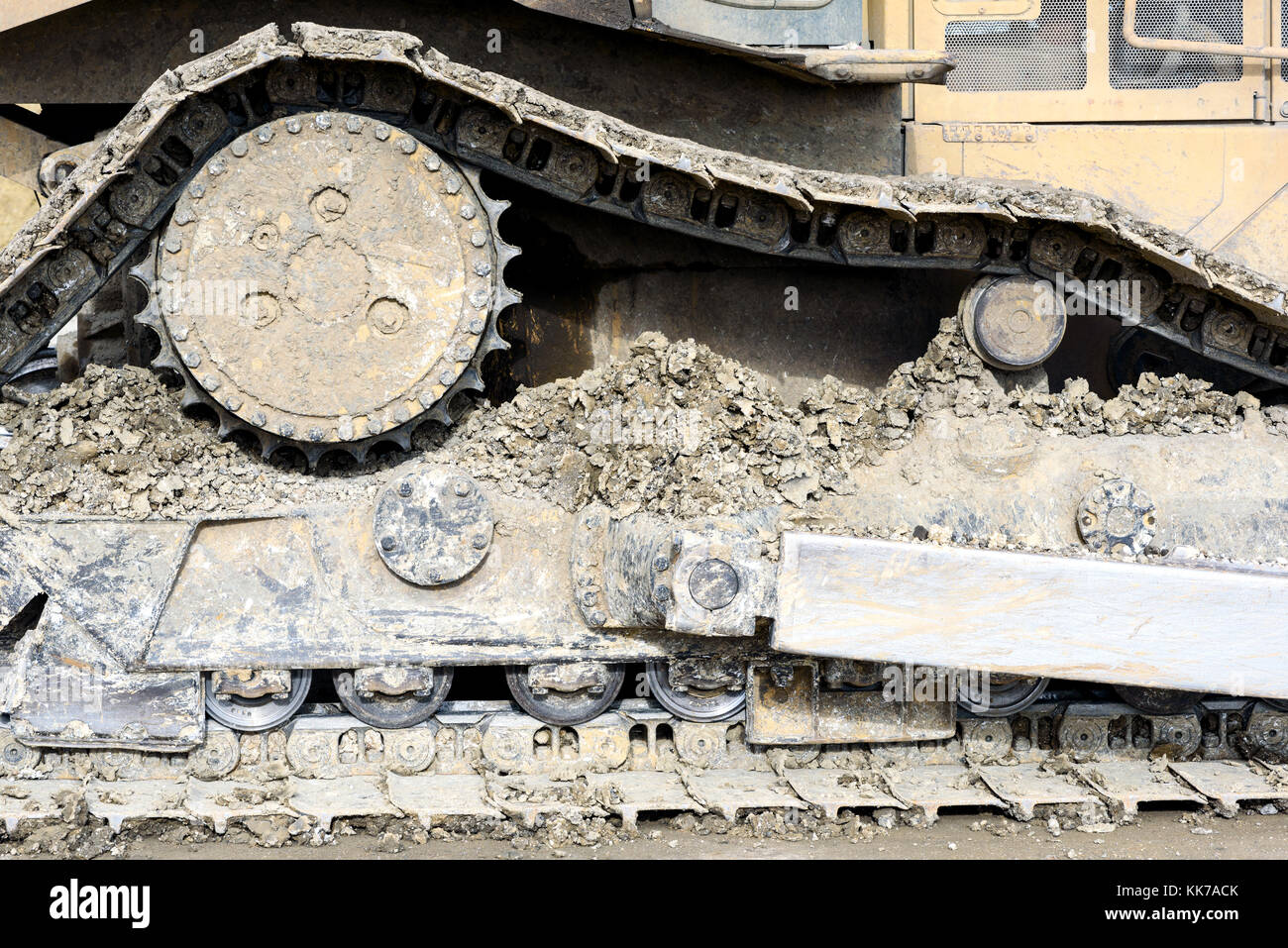 Mud clay encrusted earth moving tracks of a digger excavator machine in ...