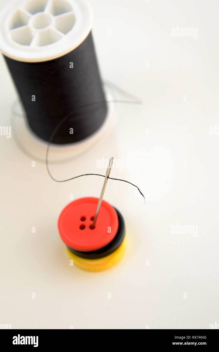 black spool of thread, needle and buttons Stock Photo - Alamy