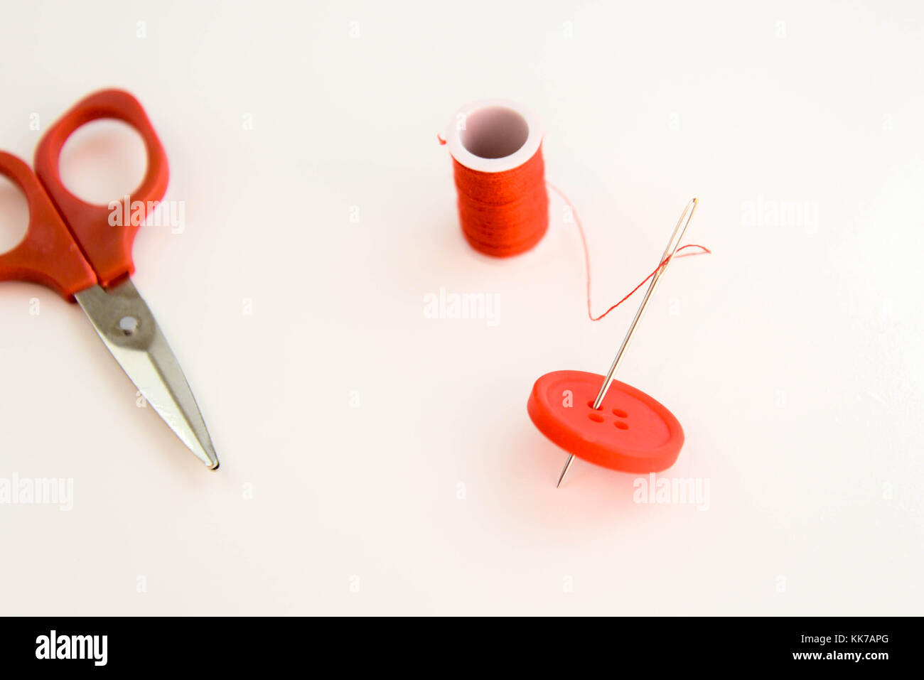 Needle threaded with red thread hi-res stock photography and images - Alamy