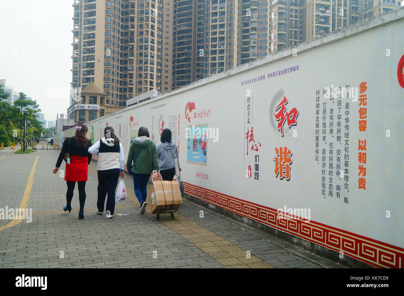 Shenzhen, China: street propaganda walls, painted walls, tourists pass ...