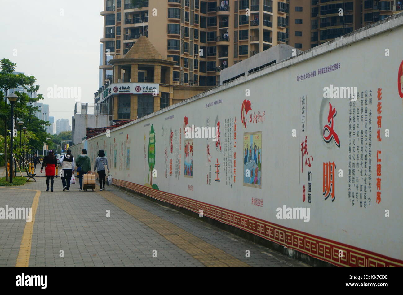 Shenzhen, China: street propaganda walls, painted walls, tourists pass ...