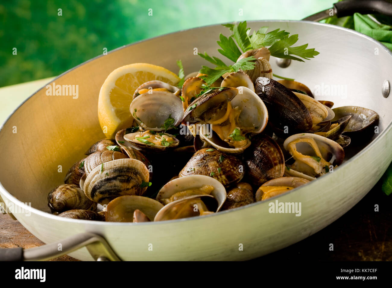 photo of delicious clams inside a pan in front of a greeb background ...
