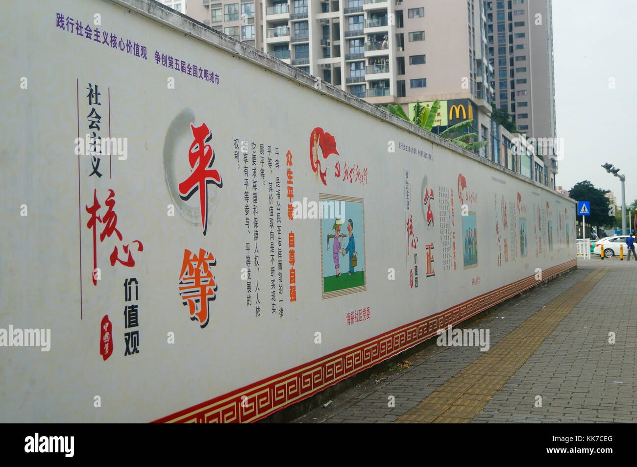 Shenzhen, China: street propaganda walls, painted walls, tourists pass ...