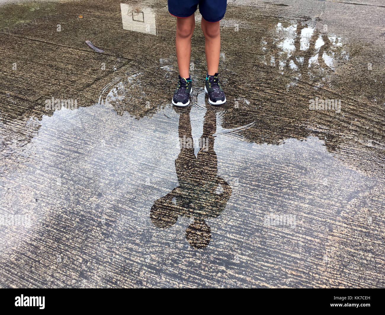 little boy in reflection of water on a pitch Stock Photo - Alamy