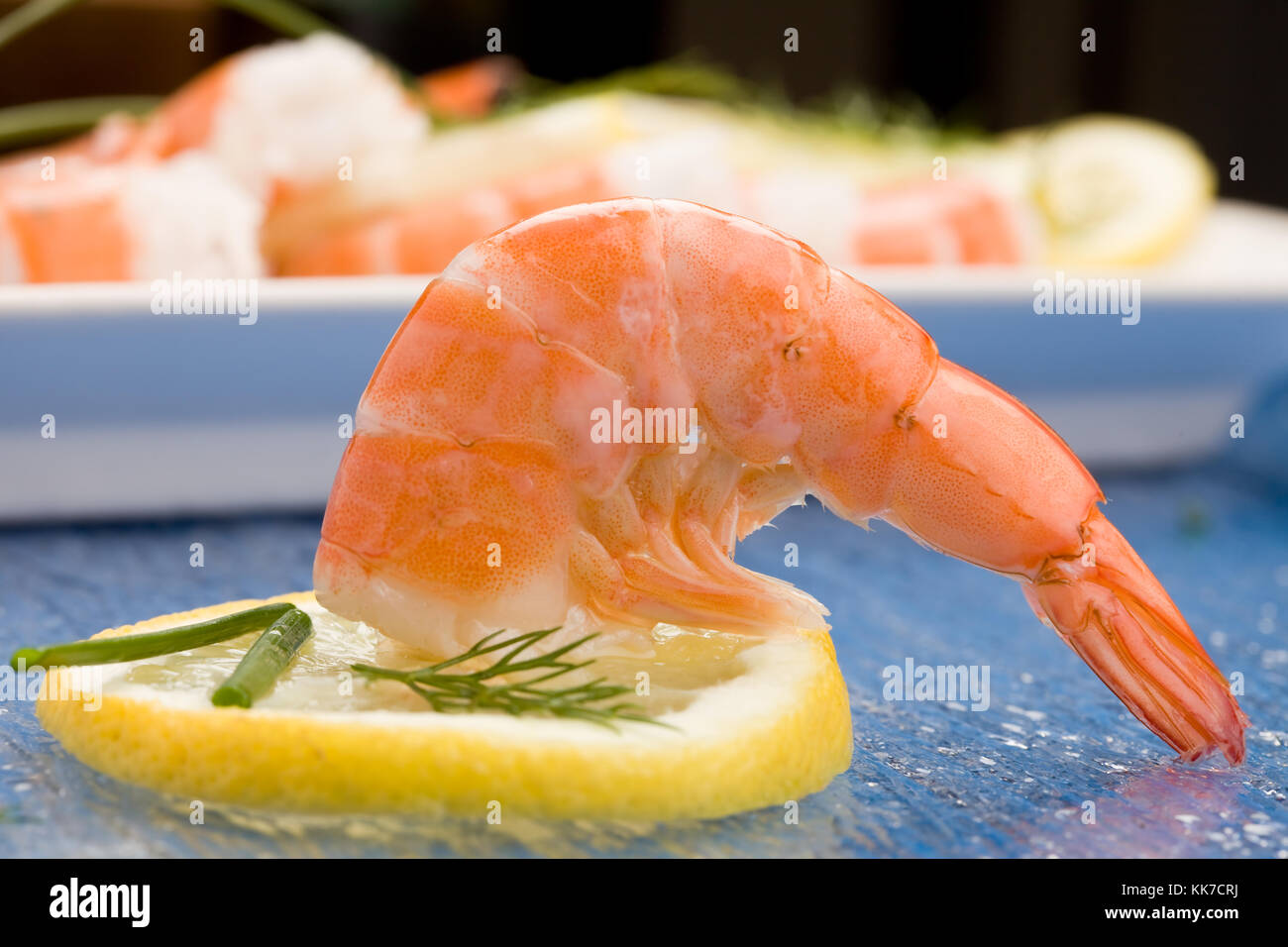 photo of delicious raw prawns with lemon slices and onions on white ...