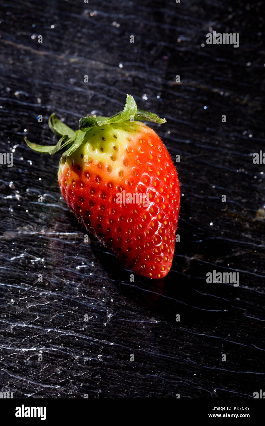 photo of red strawberry on black glass table Stock Photo - Alamy