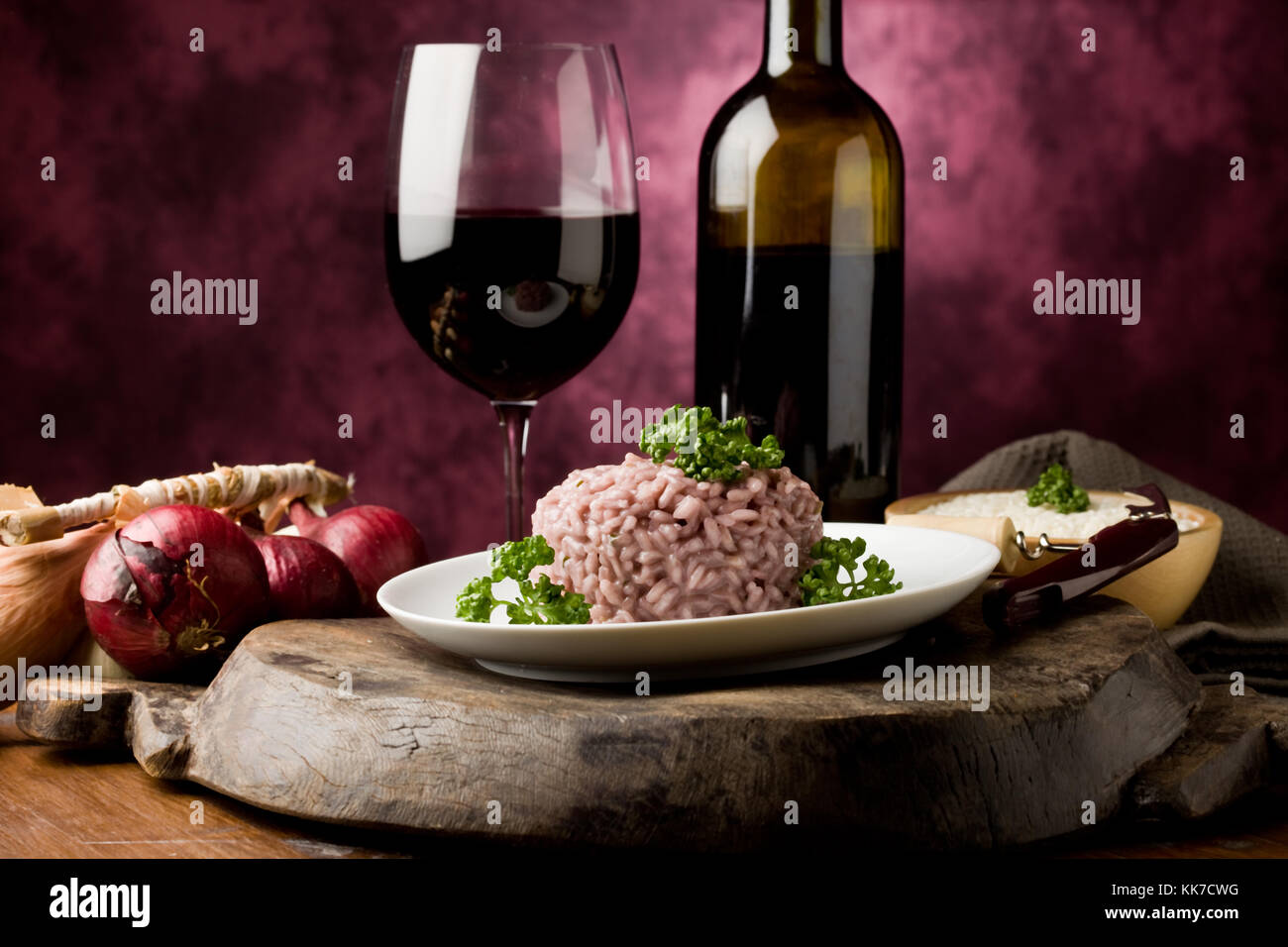 photo of delicious risotto with red wine on wooden table Stock Photo ...