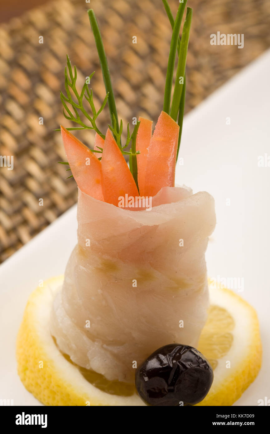 photo of delicious sea bass rolls with cutted tomatoes inside Stock ...