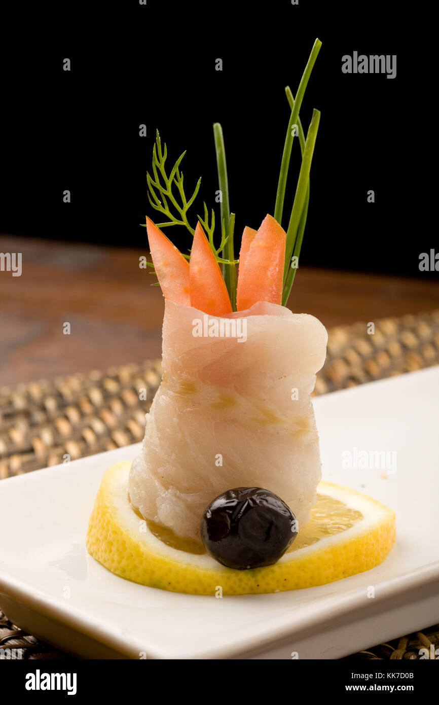photo of delicious sea bass rolls with cutted tomatoes inside Stock ...