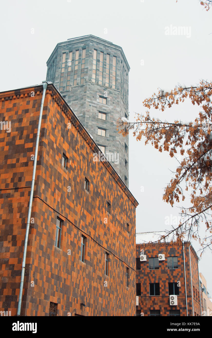 A tower and a building made of red, brown and black tuff stones ...