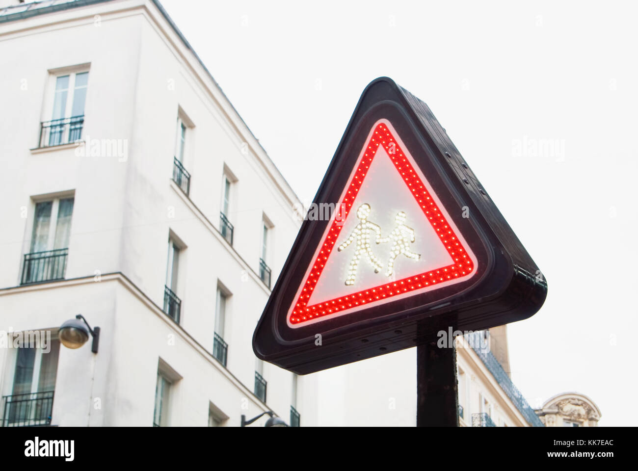 Red caution sign with two human figures, adult and child walking ...