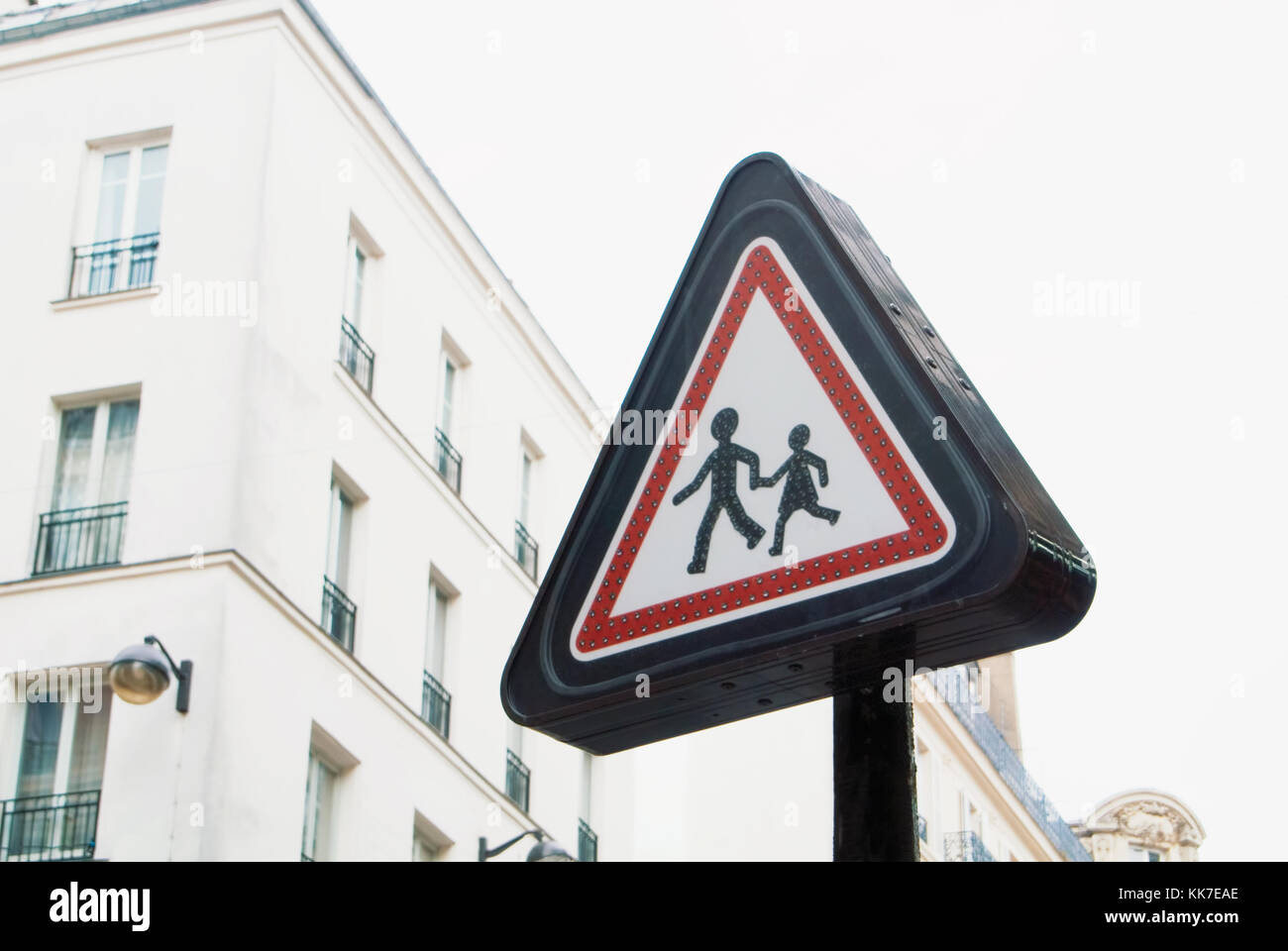 Red caution sign with two human figures, adult and child walking ...