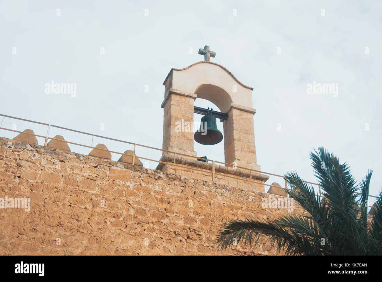 Close up of a bell over the wall of medieval moorish fortress Alcazaba ...