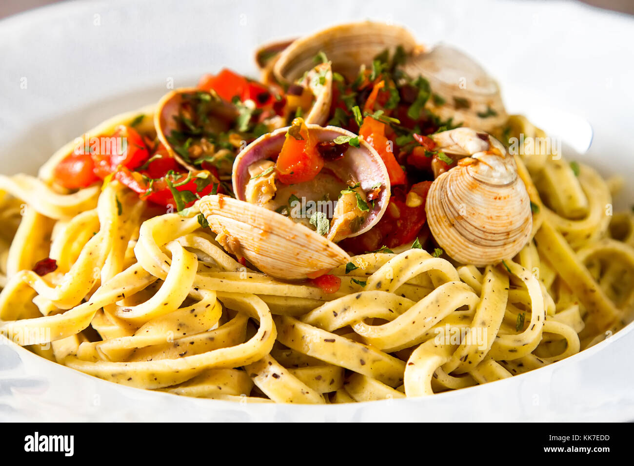 Italian tagliatelle in a restaurant with mussels and tomatoes. Dark ...
