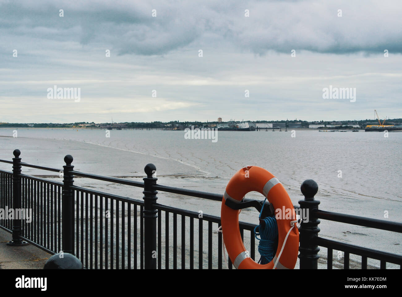 Cobbled paved footpath walkway promenade enbankment along black metal ...