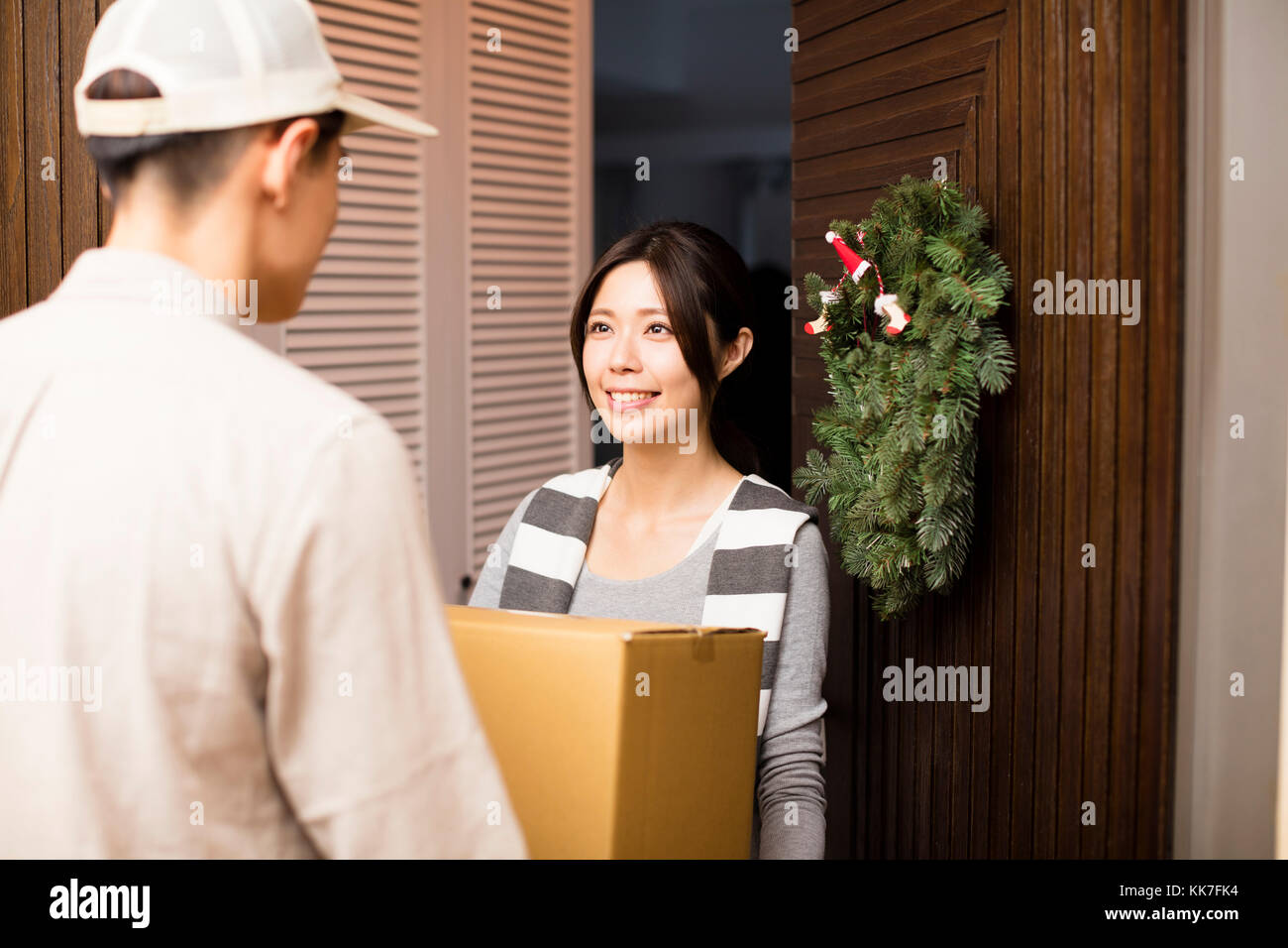 young woman receiving package from delivery man Stock Photo - Alamy