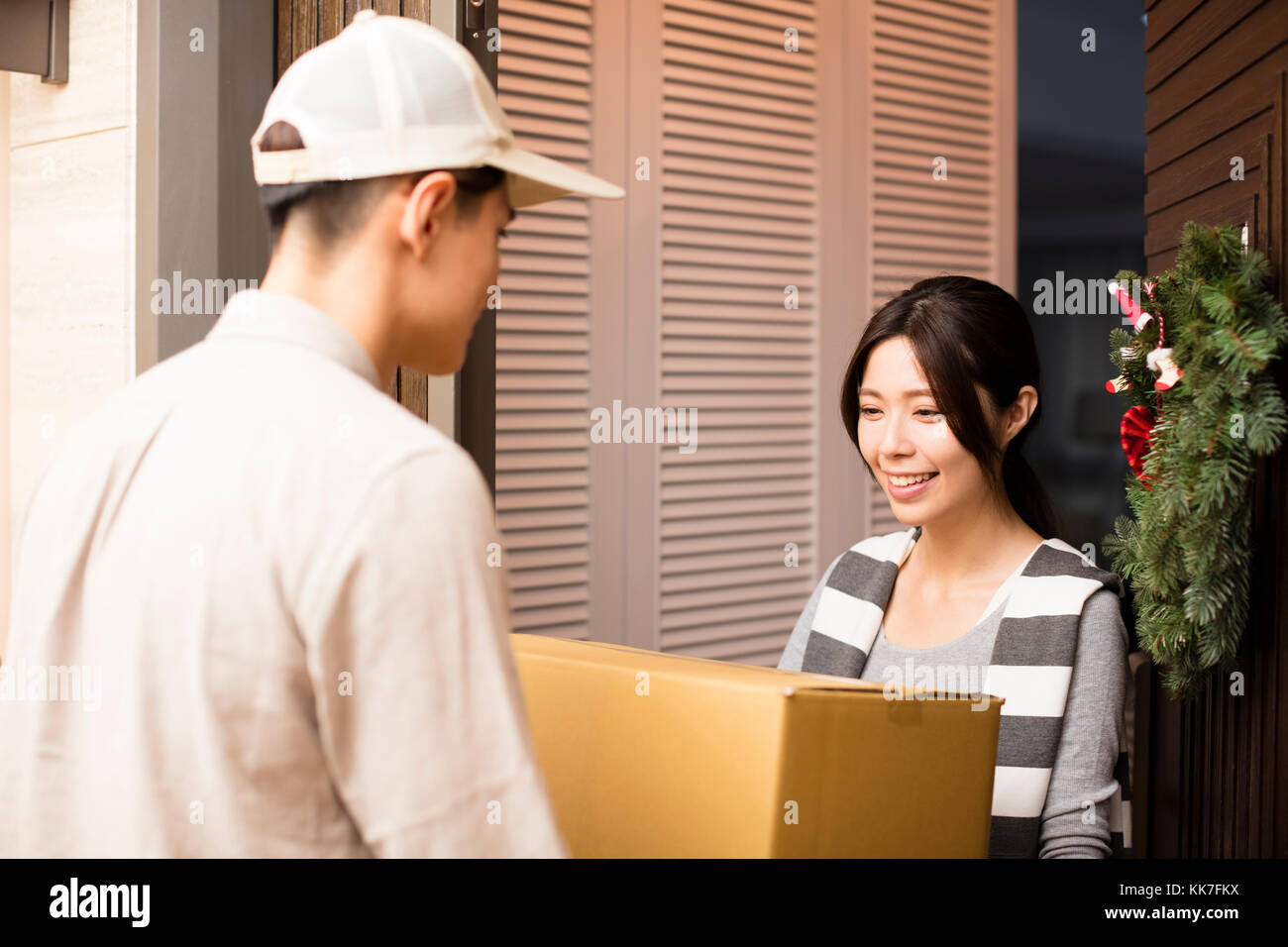 young woman receiving package from delivery man Stock Photo - Alamy