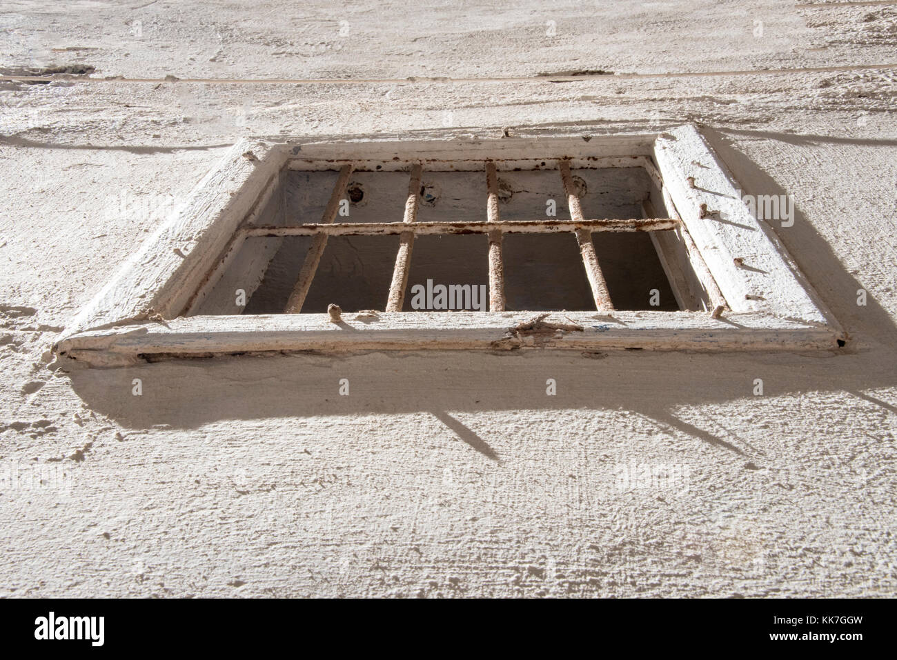 Upward view of a white window frame with a security grid in a white ...